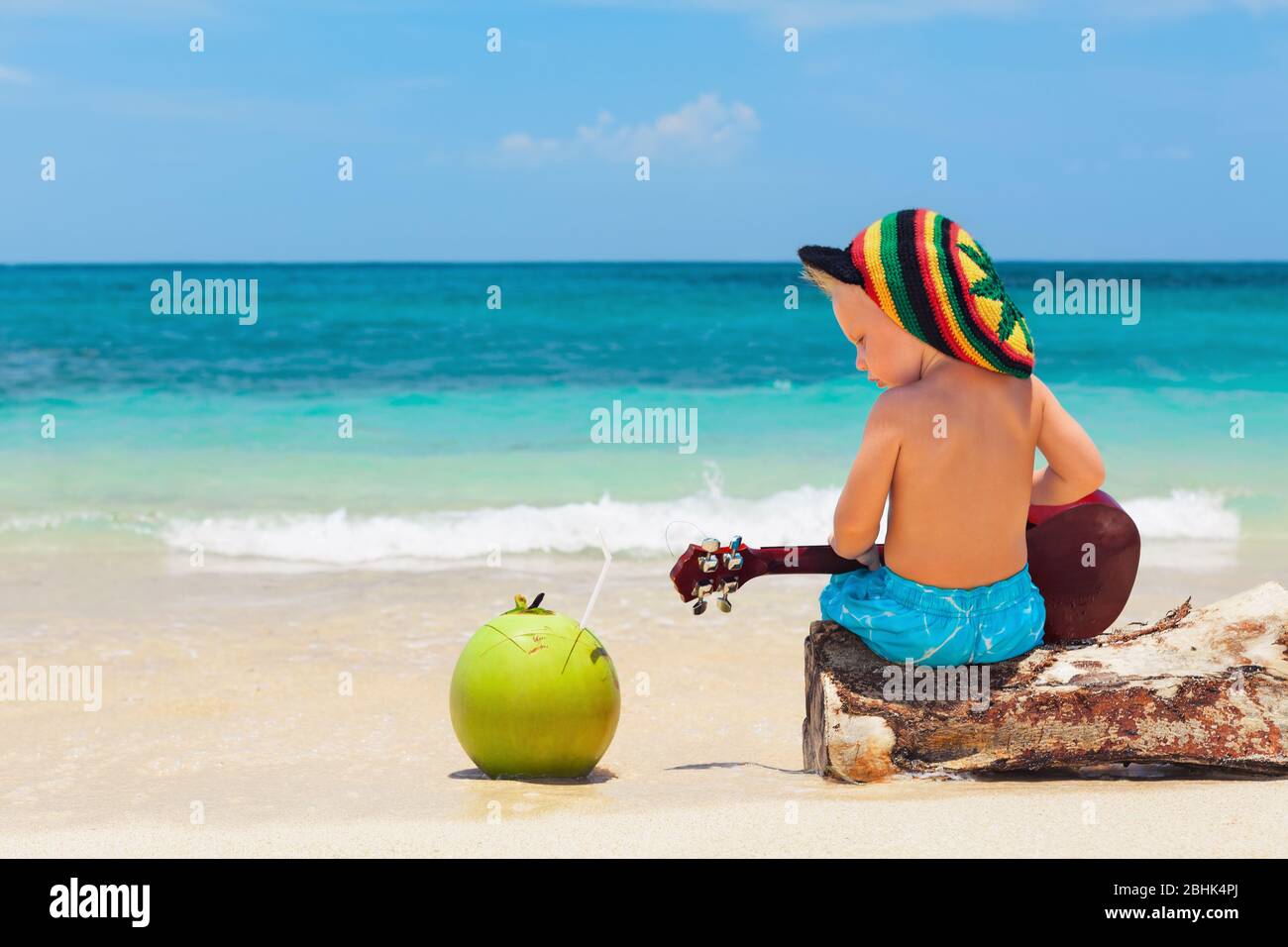 Little baby in rasta hat play reggae music on Hawaiian ukulele, enjoy ...