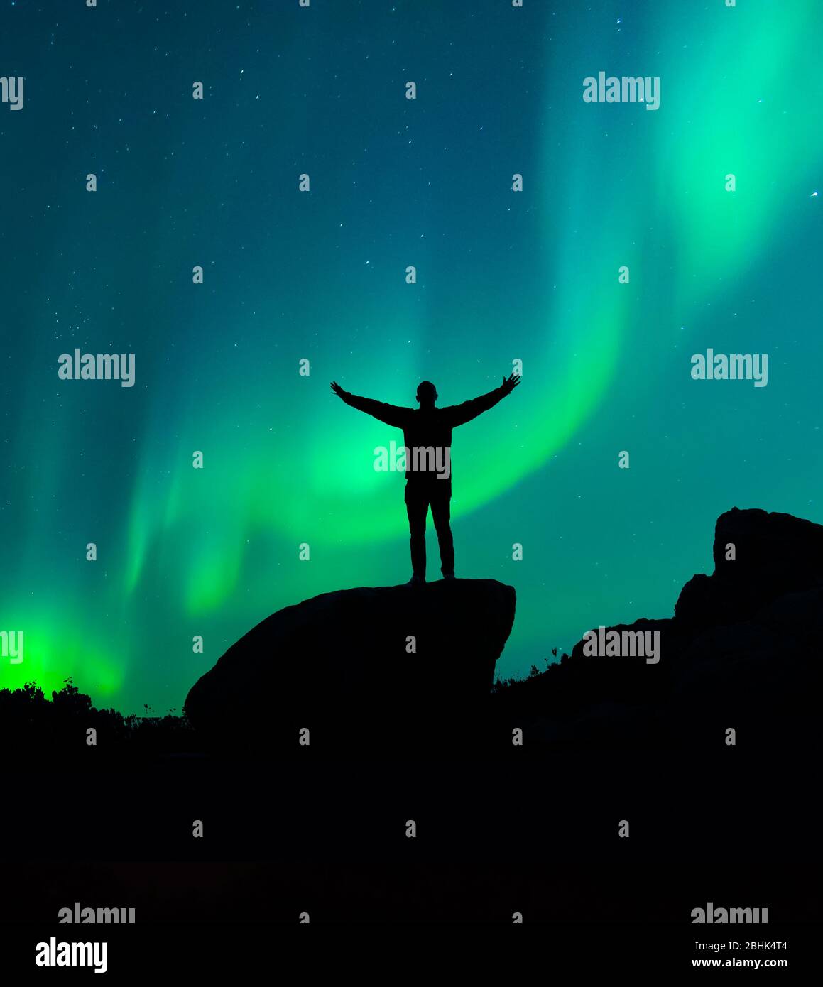 Silhouette of a man with open arms looking at a night sky with the ...