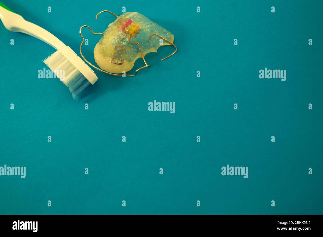 orthodontic retainer and toothbrush in the upper left corner on a blue ...