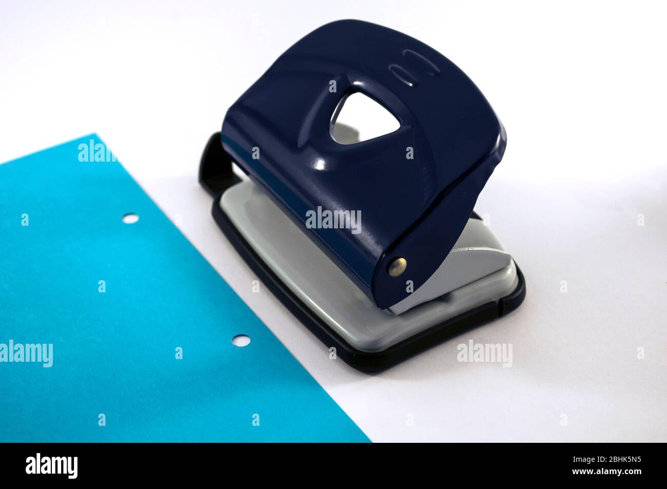 office: punch, blue paper with punch holes on a white background with ...