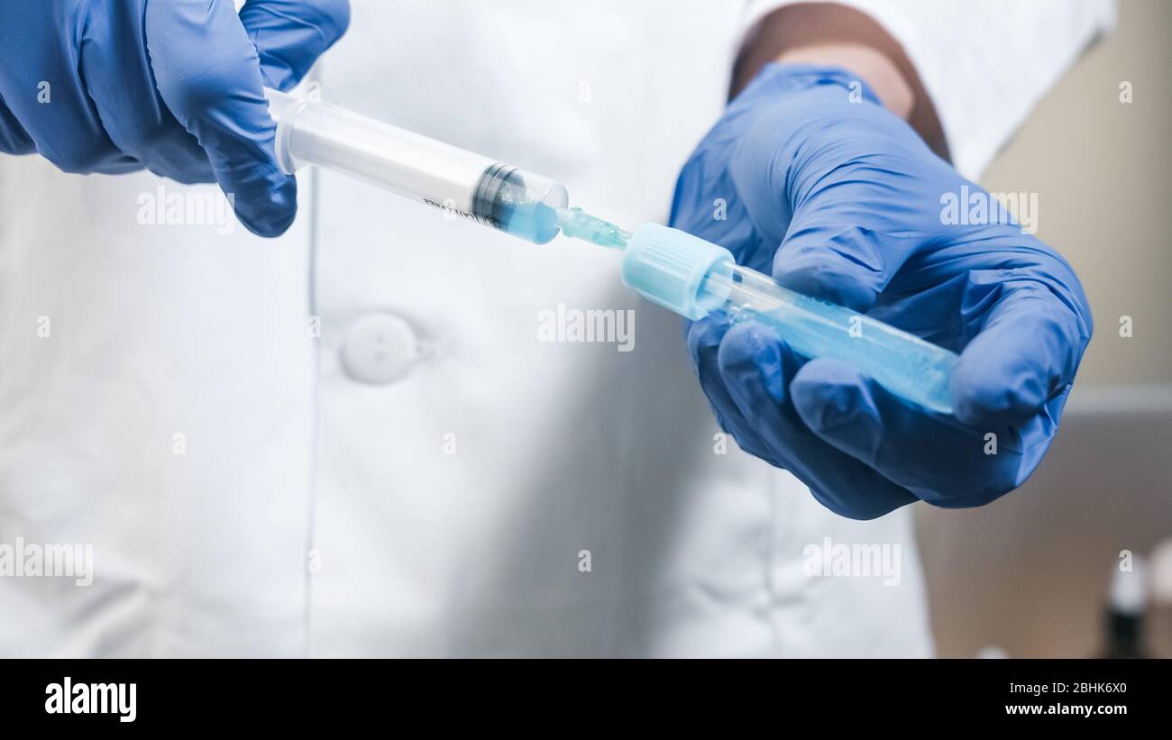 Doctor Drawing Vaccine Into Syringe in laboratory Stock Photo - Alamy