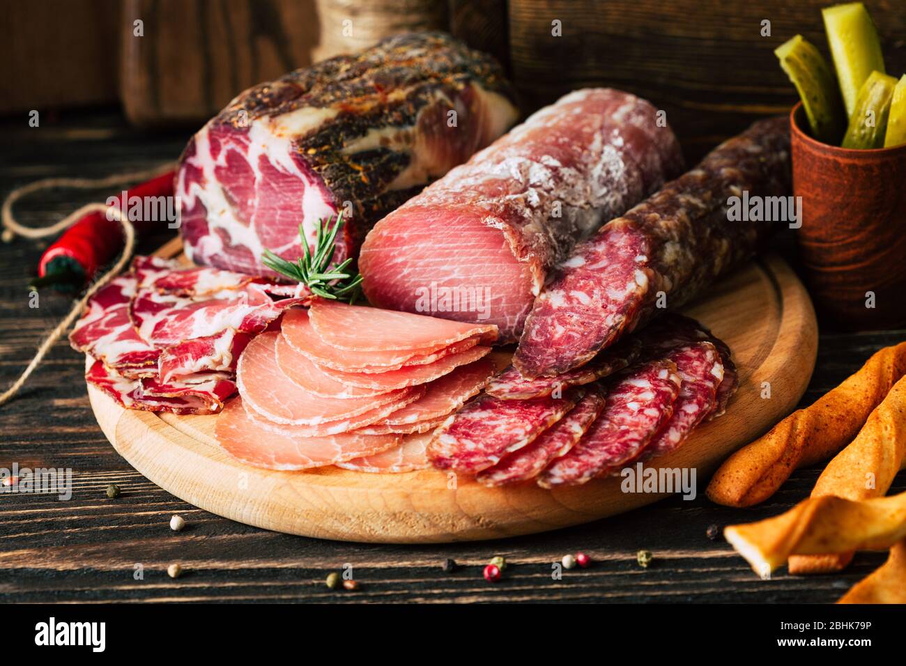 meat delicacies on wooden background, dried sausage on a cutting board ...