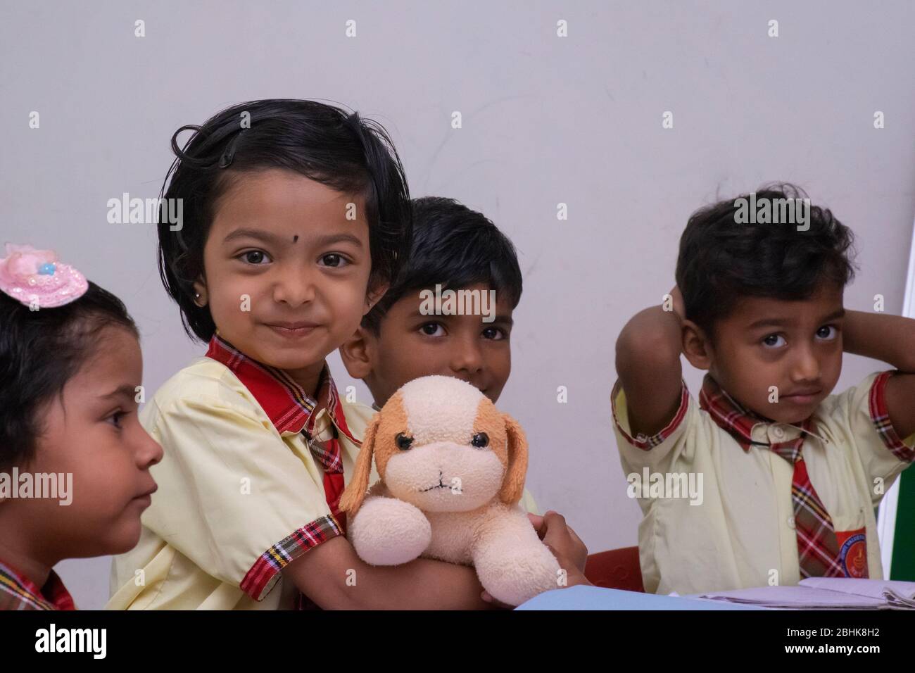 Young primary or elementary school children sitting at their desks in a ...