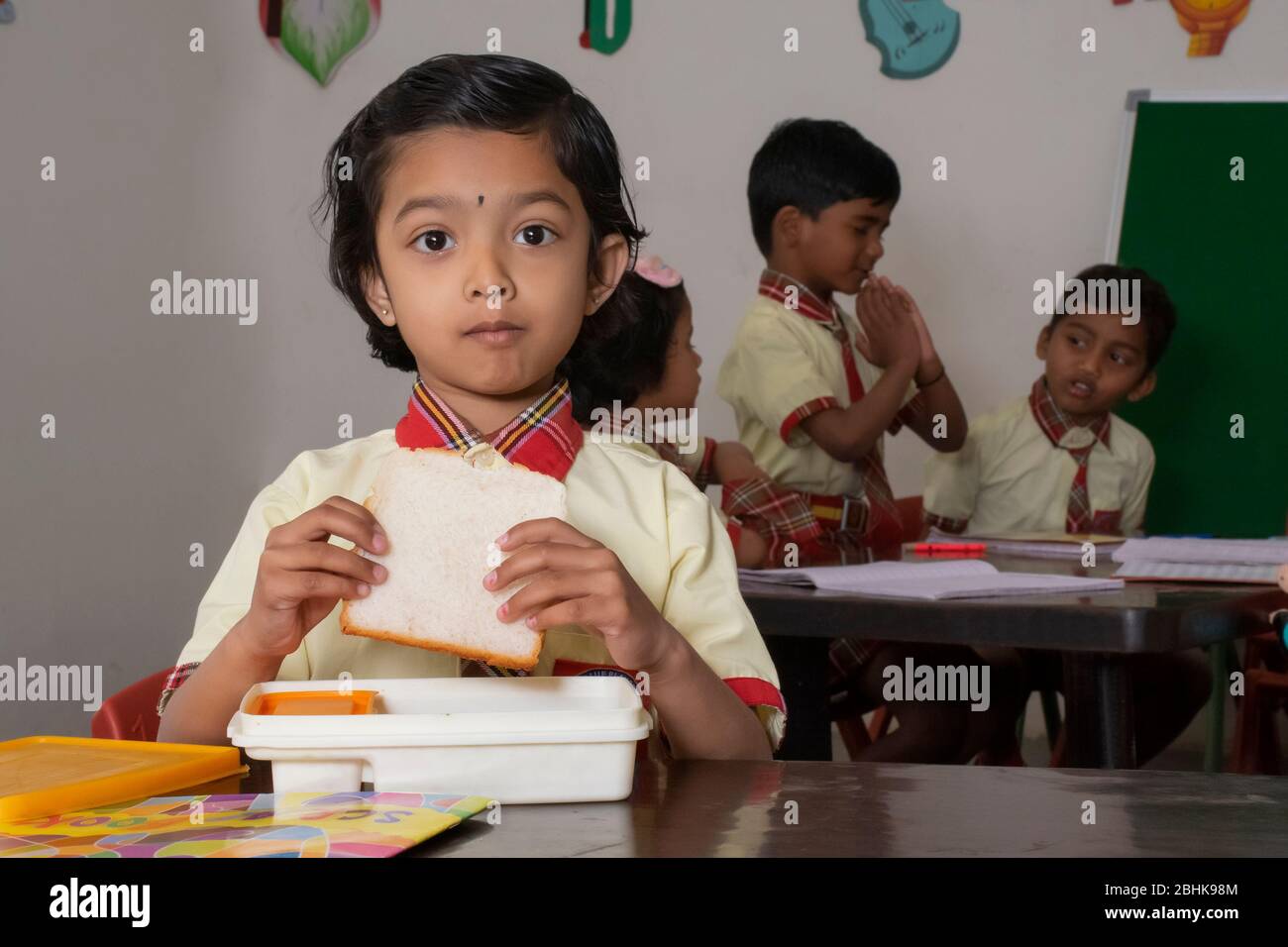 Elementary school girls eating at school lunch table Stock Photo - Alamy