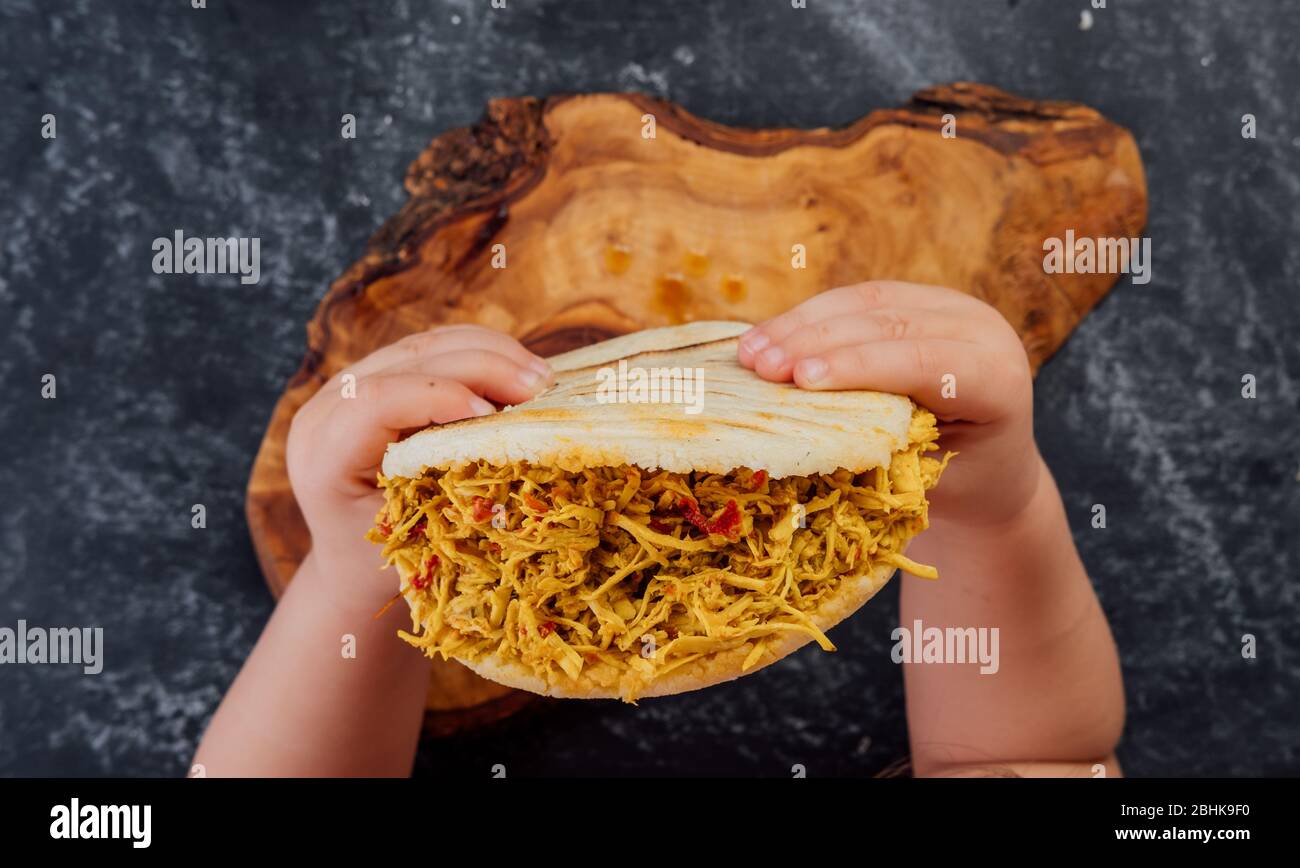 Boy holding an arepa, typical of Latin American cuisine Stock Photo - Alamy
