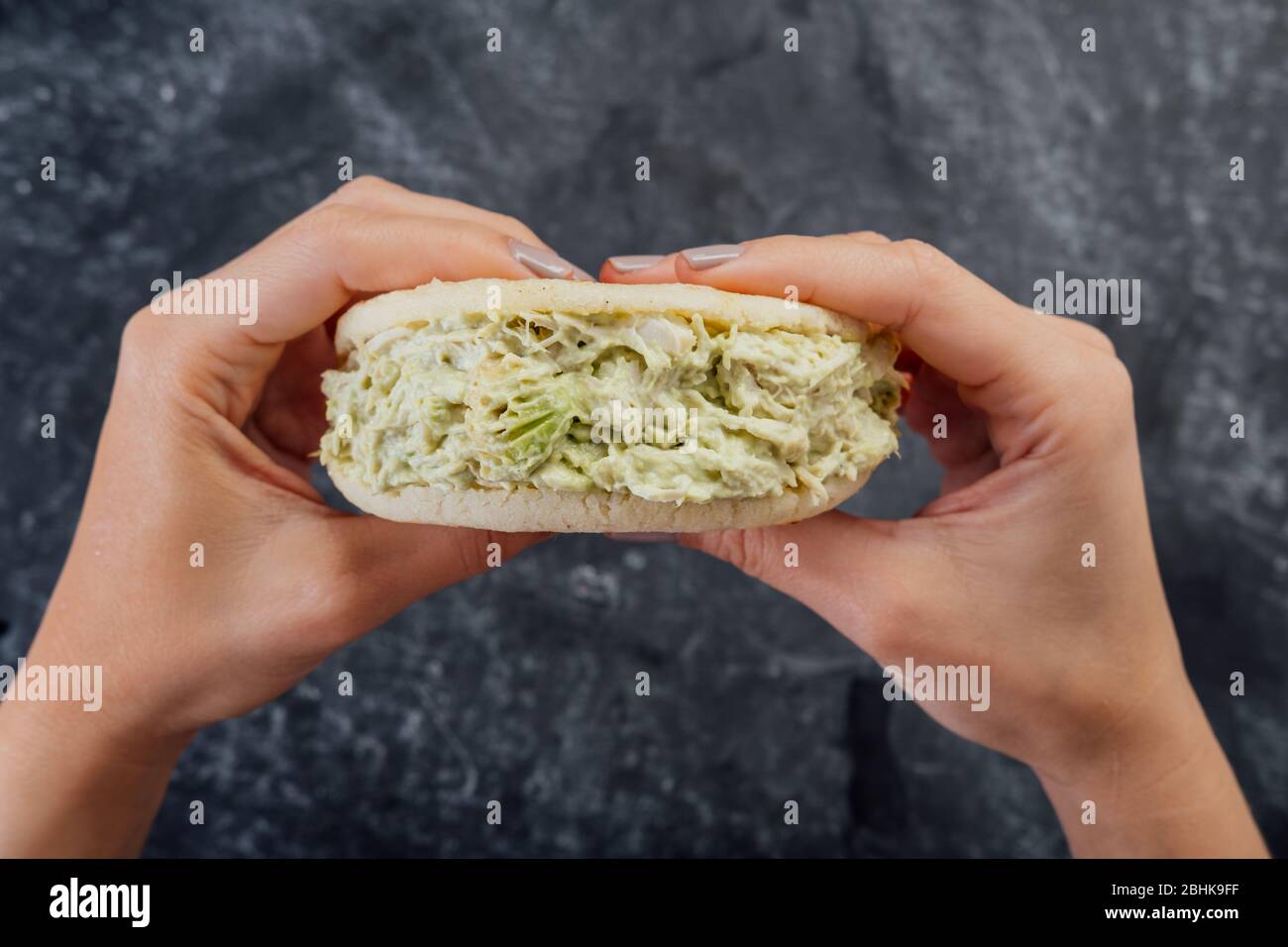 Woman holding a pepeada queen arepa typical of Venezuelan cuisine Stock ...