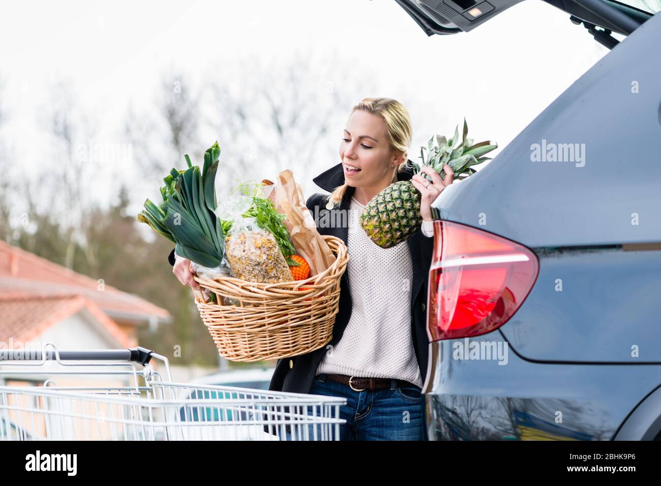 Woman loading groceries after shopping into trunk of her car Stock ...
