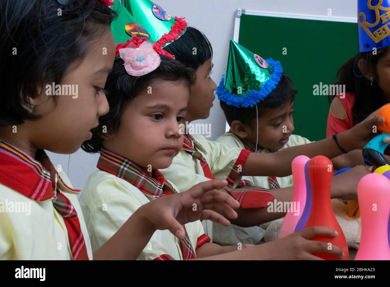 Young primary or elementary school children learning and playing desk ...