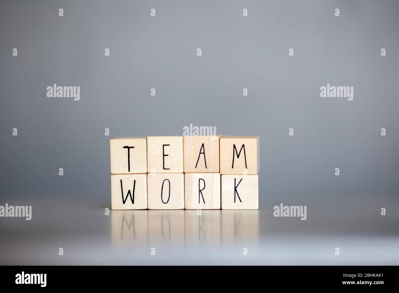 Wooden cubes with the words Team Work for business concept on grey blue ...