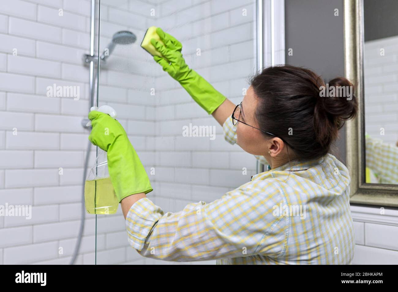 Woman doing cleaning in the bathroom, at home. Female washing shower ...