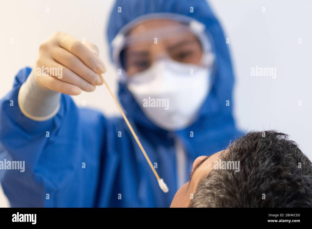 Swab test by NHS worker to a patient with blue full PPE during covid19 ...