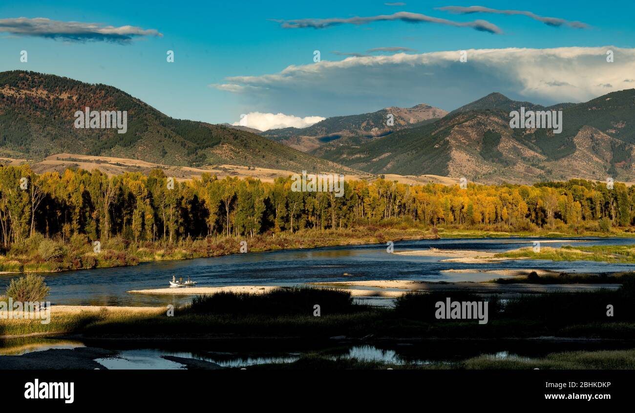Beautiful fishing scene with a boat rover and mountains Stock Photo - Alamy