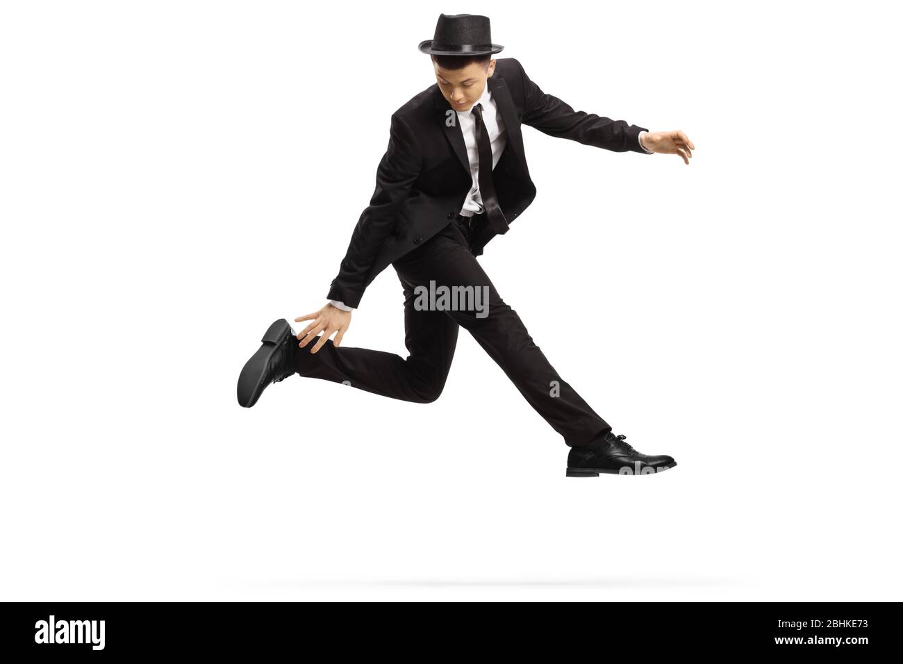 Young man in a suit in a jumping dance pose isolated on white ...