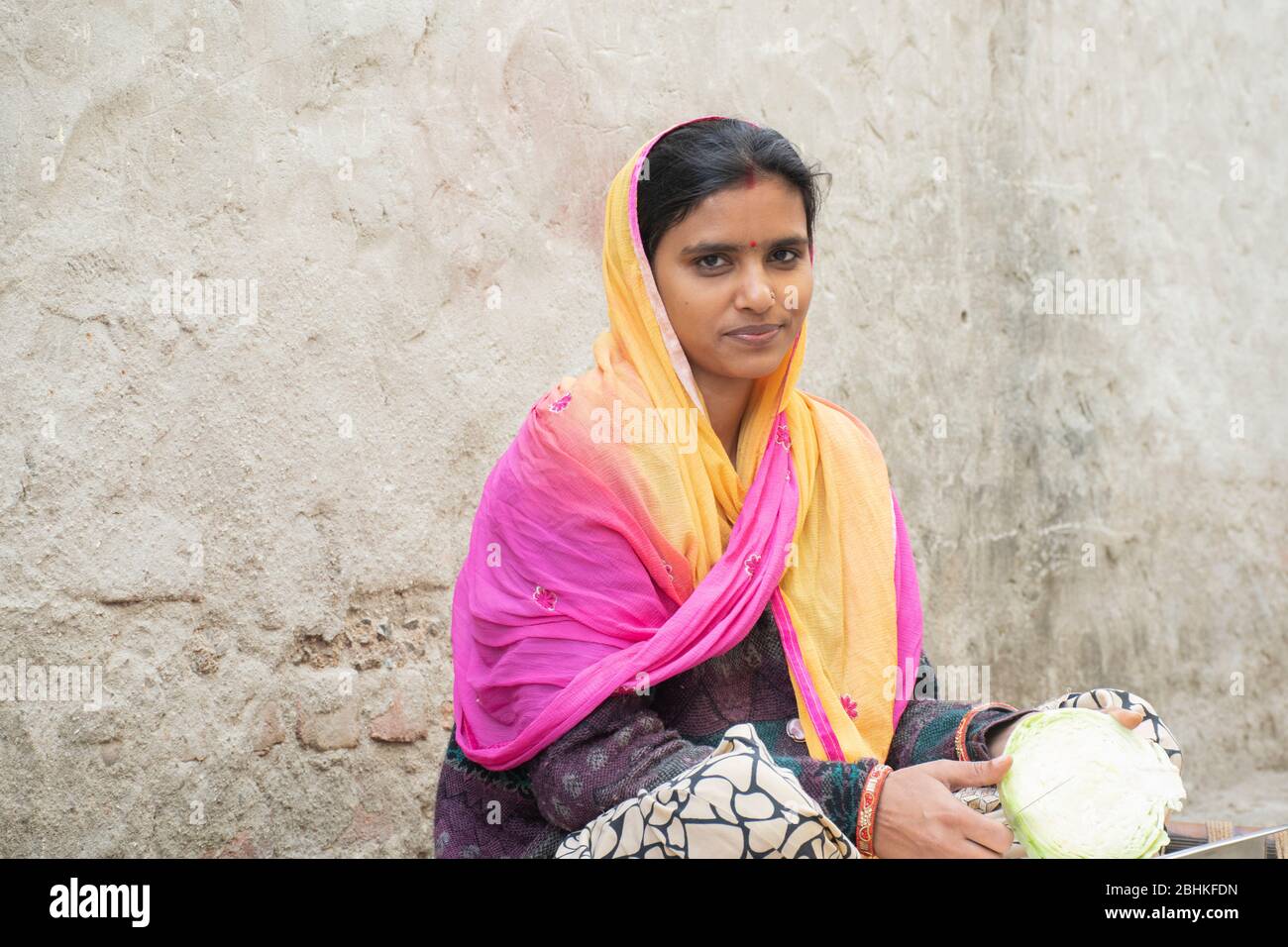 indian Rural villager woman sitting Charpai and Cutting Vegetable Stock ...