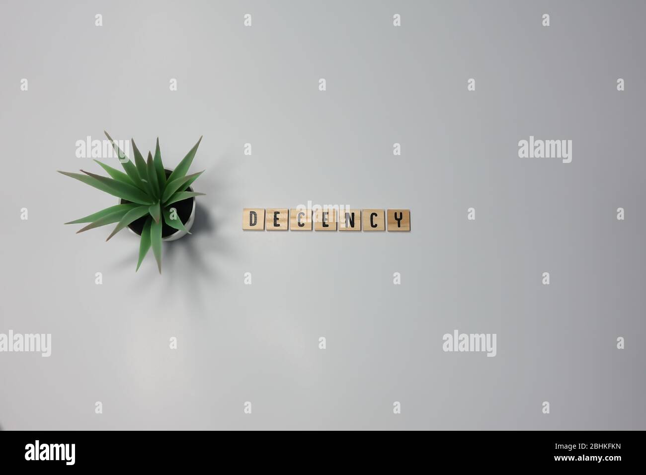 The word Decency written in wooden letter tiles on a white background ...