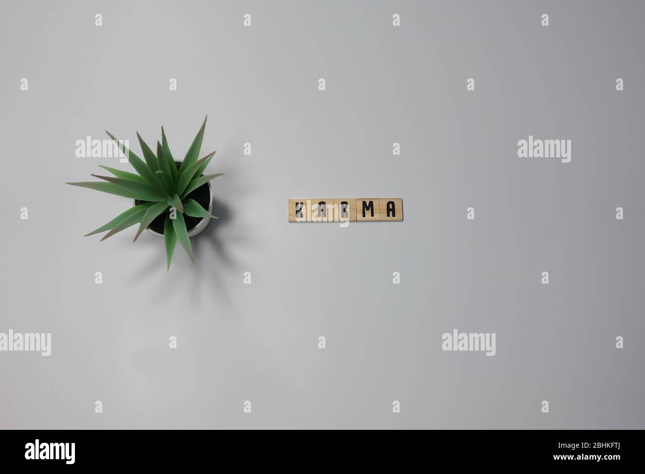 The word Karma written in wooden letter tiles on a white background ...