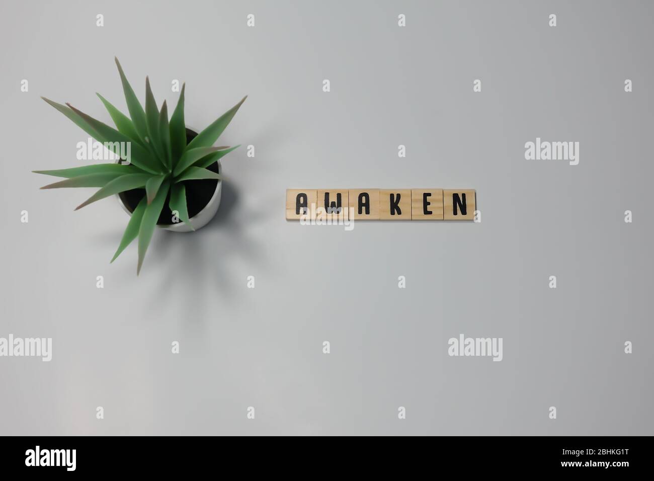 The word Awaken written in wooden letter tiles on a white background ...