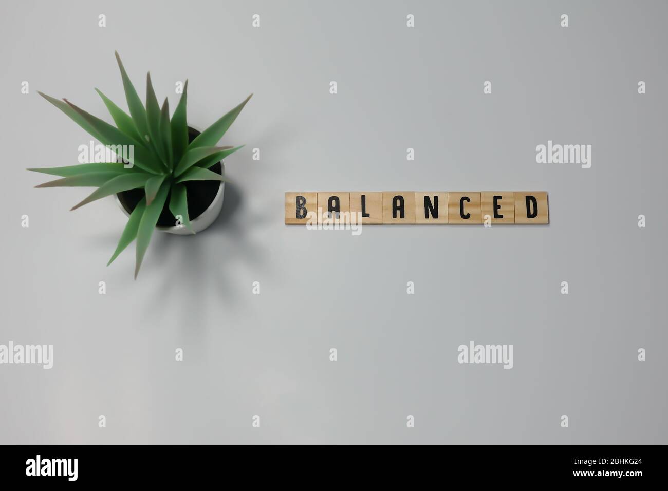 The word Balanced written in wooden letter tiles on a white background ...
