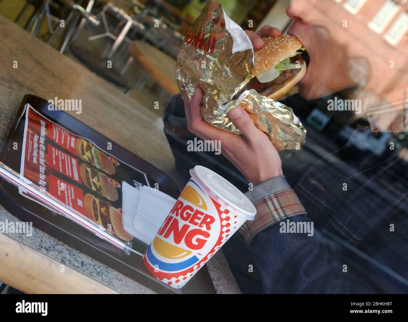 A Burger King customer eating his burger Stock Photo - Alamy