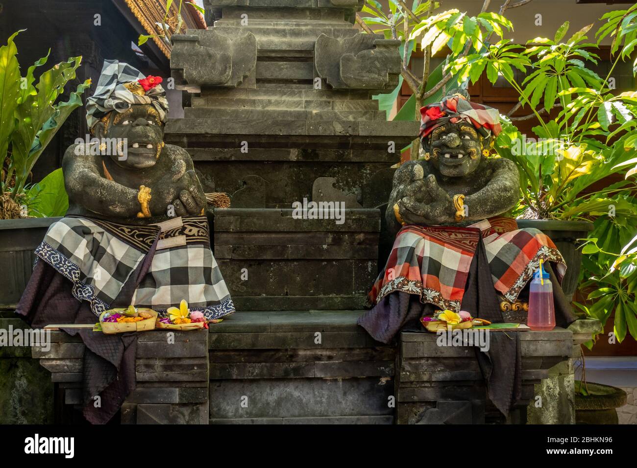 Two Hindu statues in ceremonial dress sitting on the steps guarding the ...