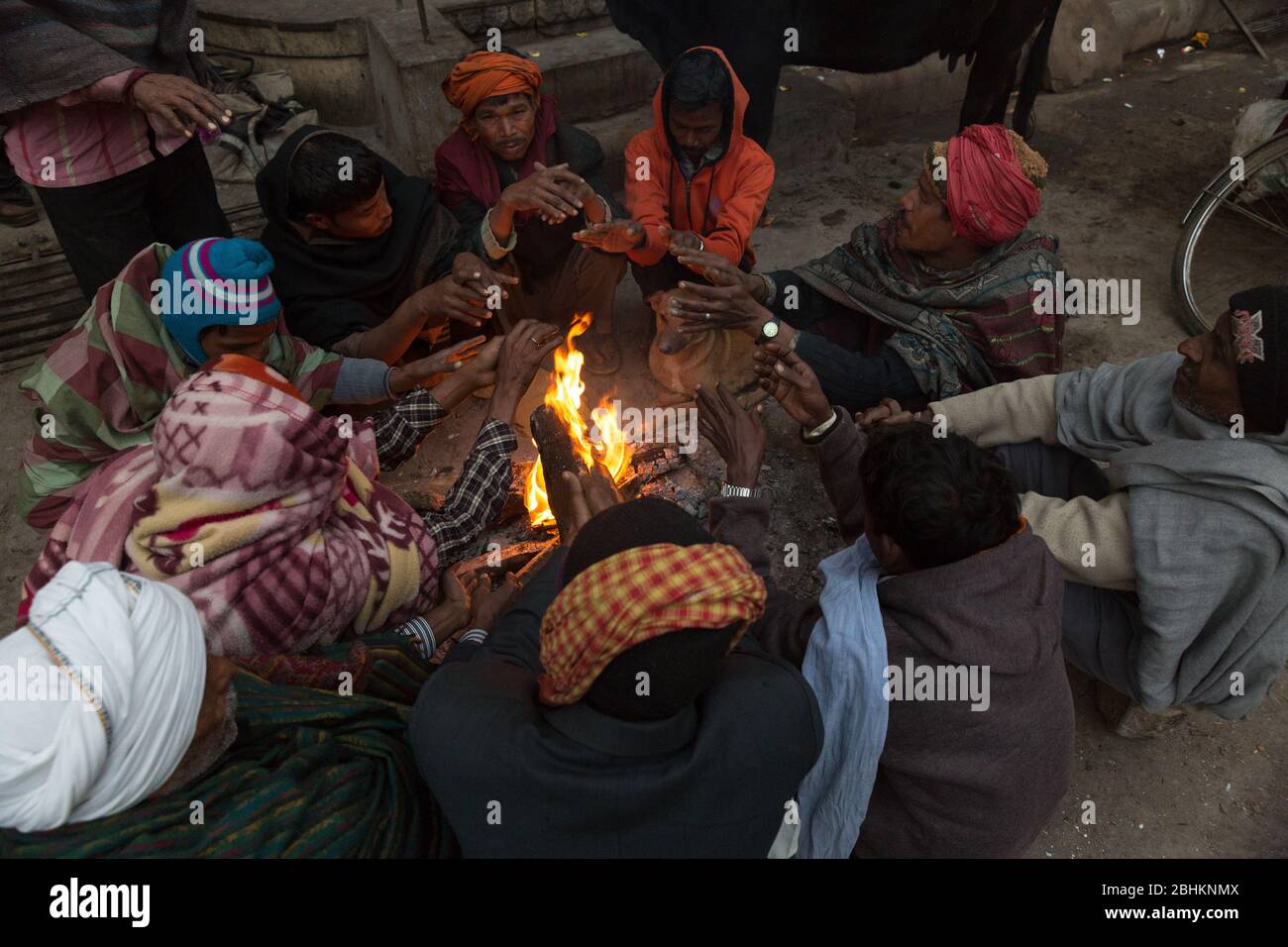 Early morning on the streets of Varanasi, India. People having bonfire ...