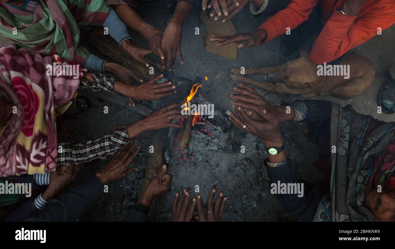Early morning on the streets of Varanasi, India. People having bonfire ...