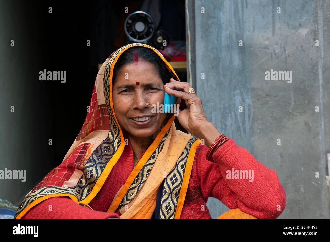 Indian woman talking on a mobile phone and smiling Stock Photo - Alamy