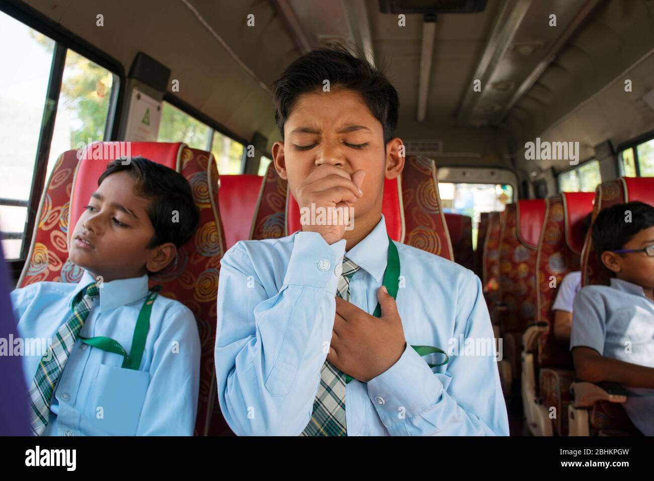 boy coughing in school bus Stock Photo - Alamy