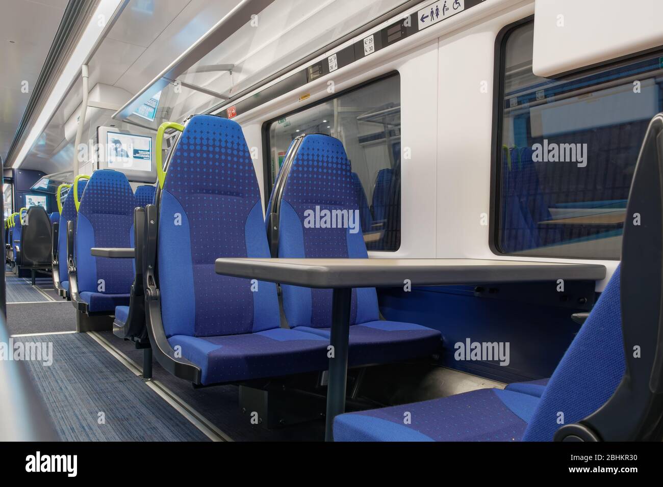 Interior of UK empty train stopped at station. Seat layout with tables ...