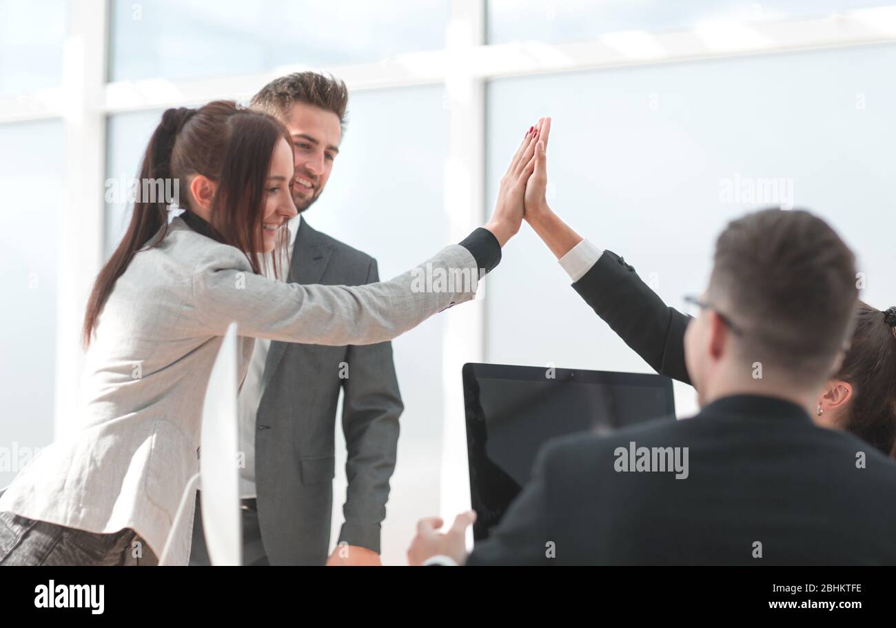 young employees giving each other a high five in the workplace Stock ...
