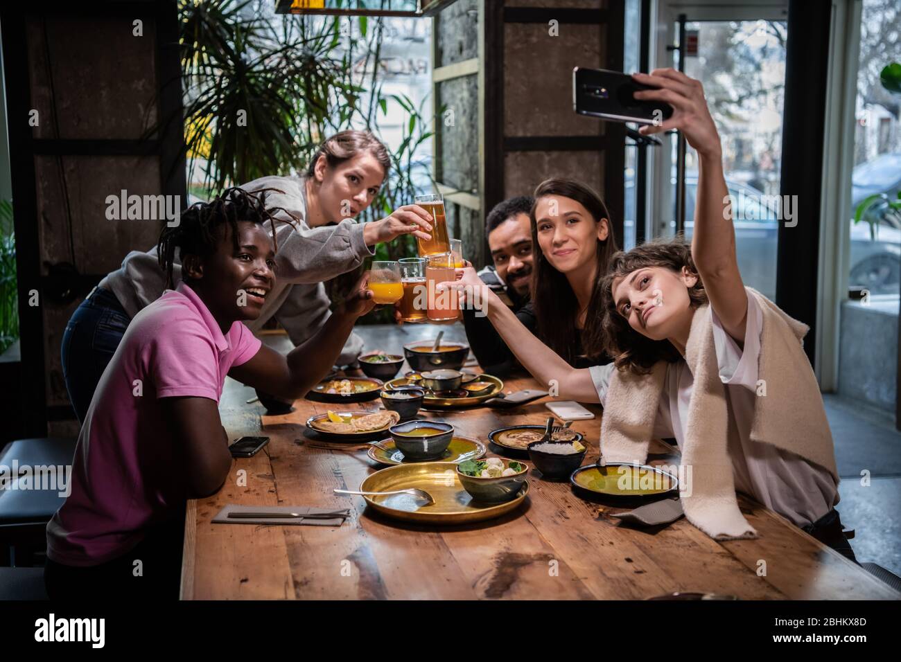 A group of teens taking photos of themselves, making crazy faces. In a ...