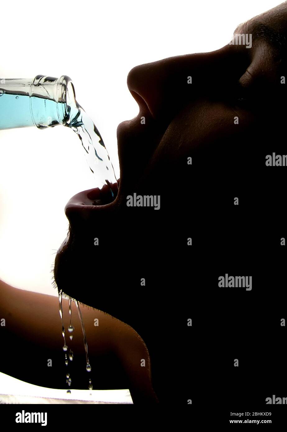 Side view of a man drinking alcohol. Alcohol is an addictive substance ...