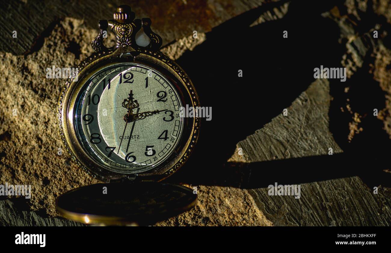 Vintage pocket watch on the cracked concrete floor with the shadow ...
