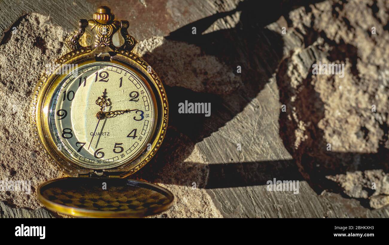 Vintage pocket watch on the cracked concrete floor with the shadow ...