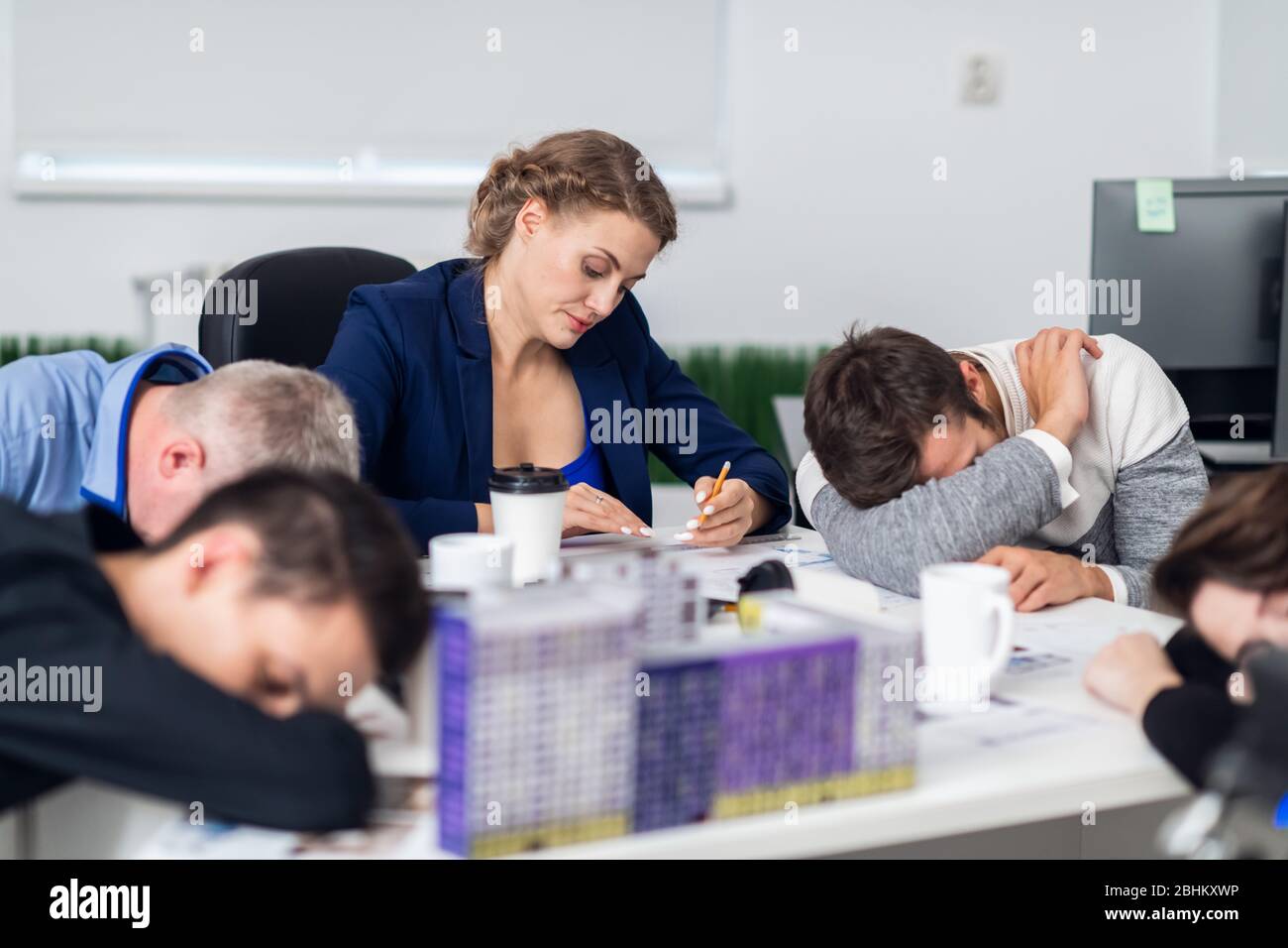 Business people sleeping in the office, while some still keep working ...