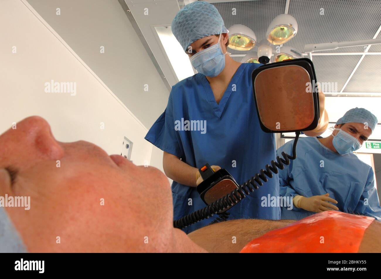 Doctors using a defibrillator to resuscitate a male heart attack victim ...