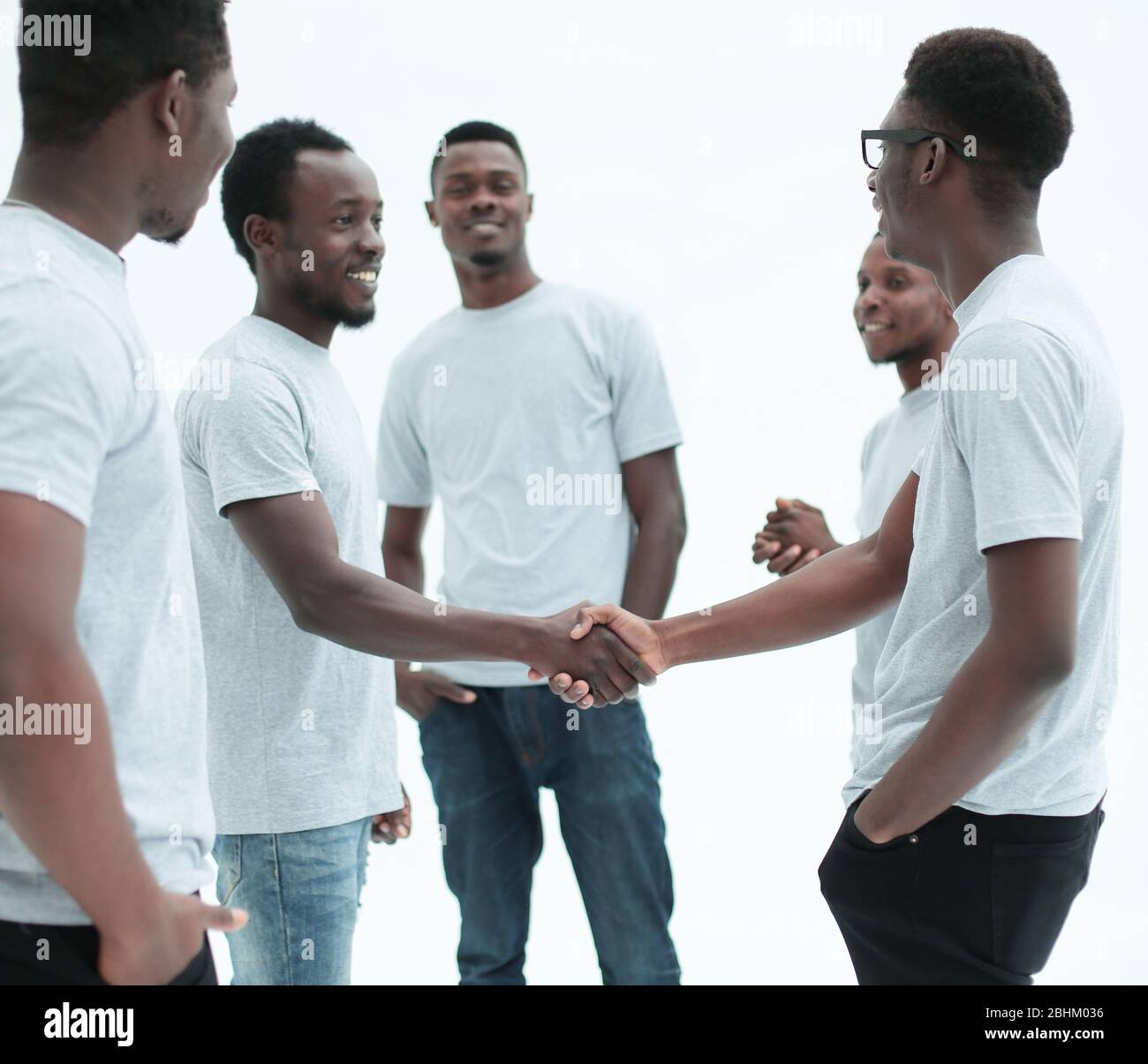 in full growth. smiling friends shaking hands Stock Photo - Alamy