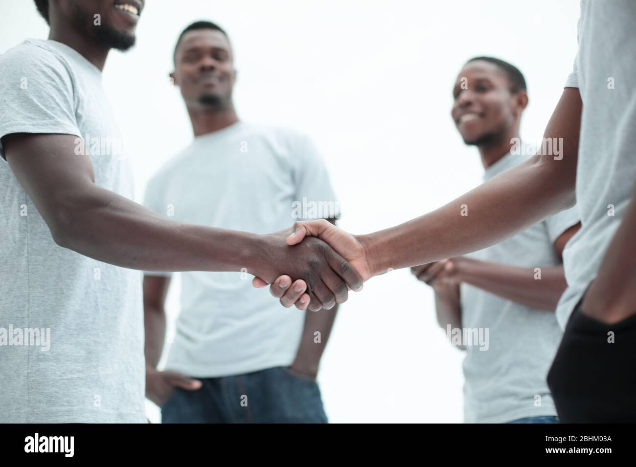 smiling guys shaking hands. isolated on white Stock Photo - Alamy