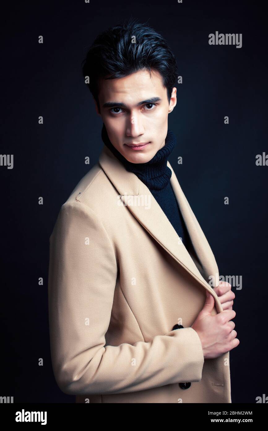 handsome asian fashion looking man posing in studio on black background ...