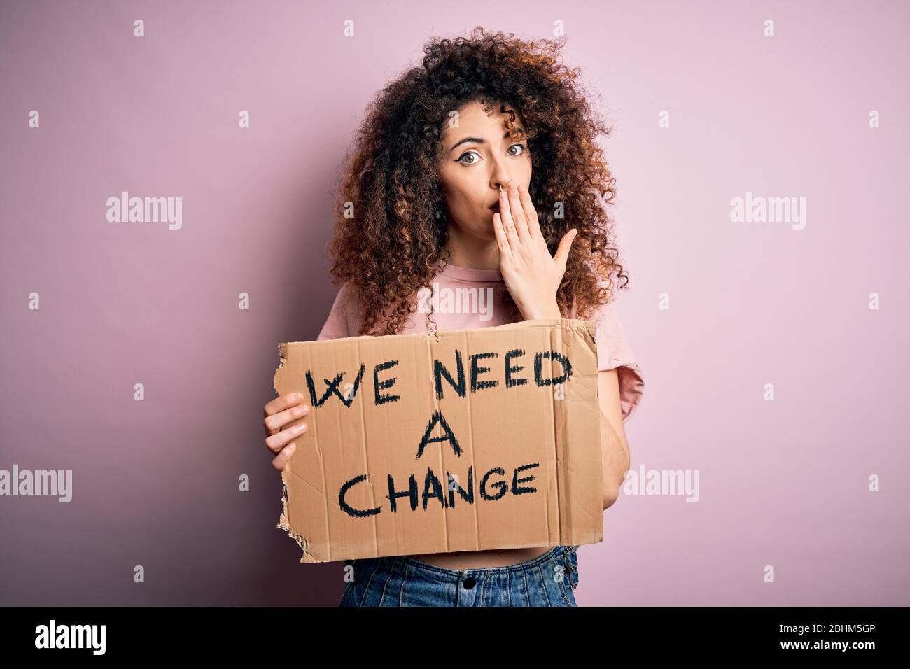 Young beautiful activist woman with curly hair and piercing protesting ...