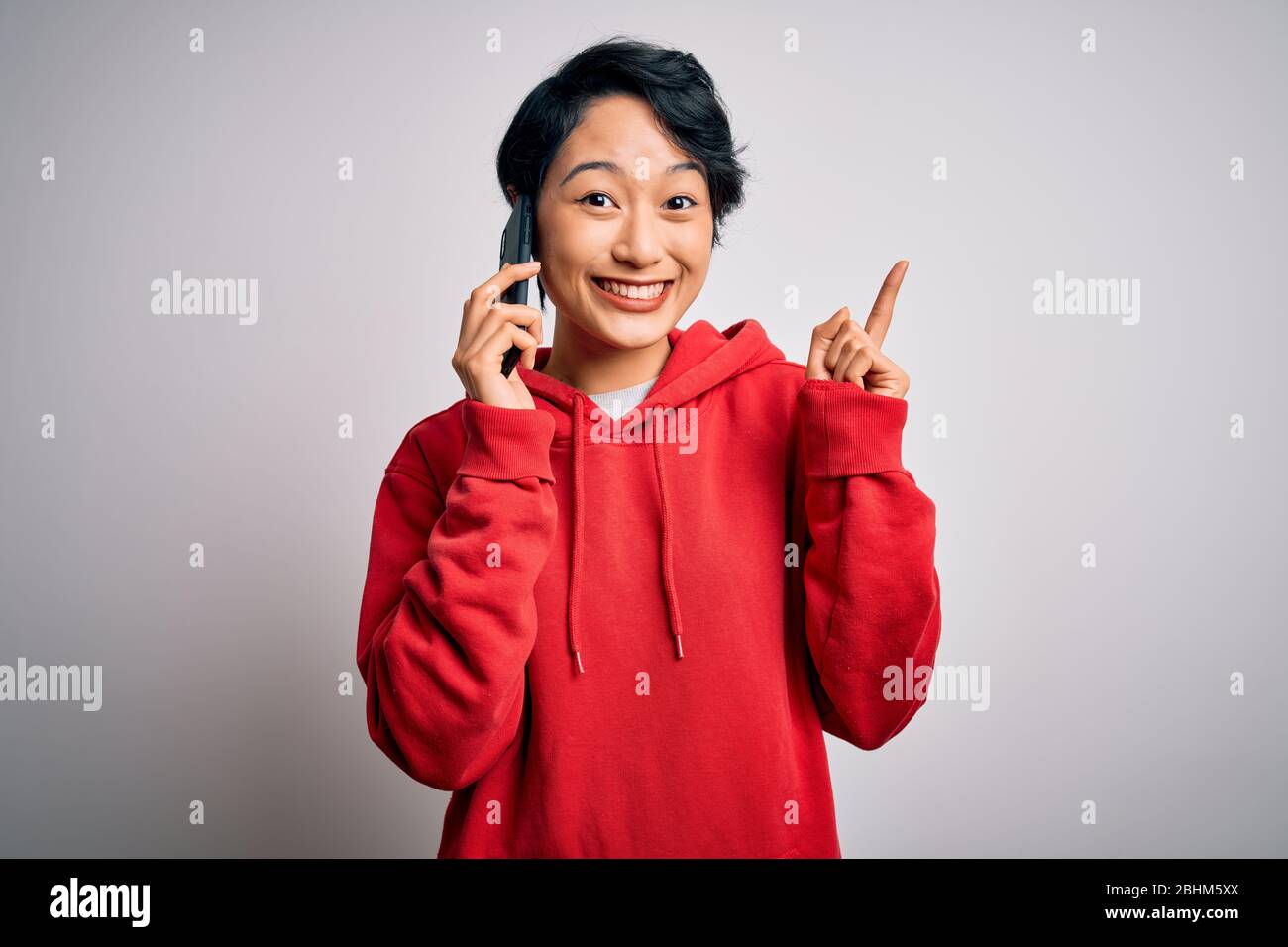 Young beautiful asian girl having conversation talking on the ...