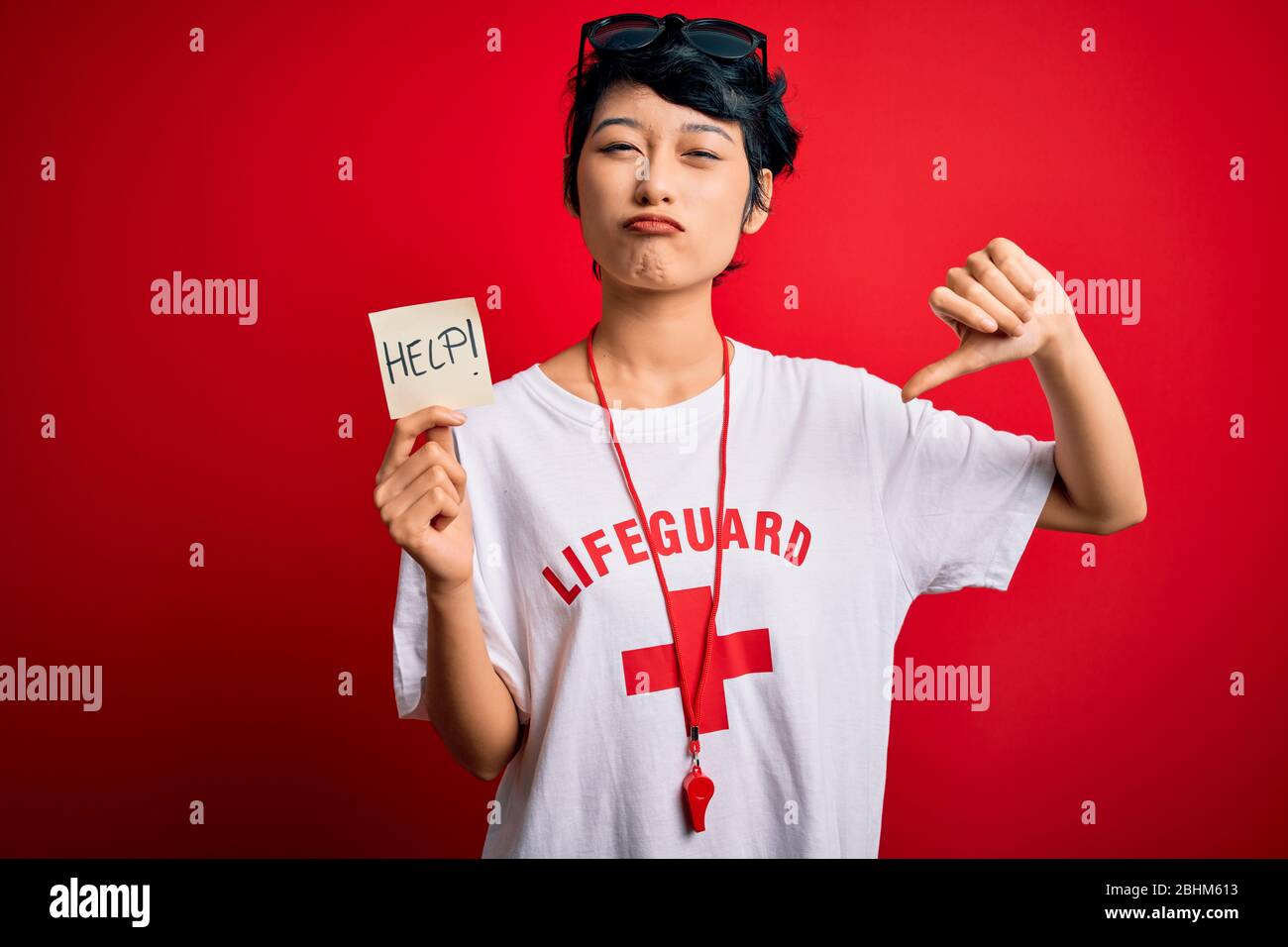 Young beautiful asian lifeguard girl using whistle holding reminder ...