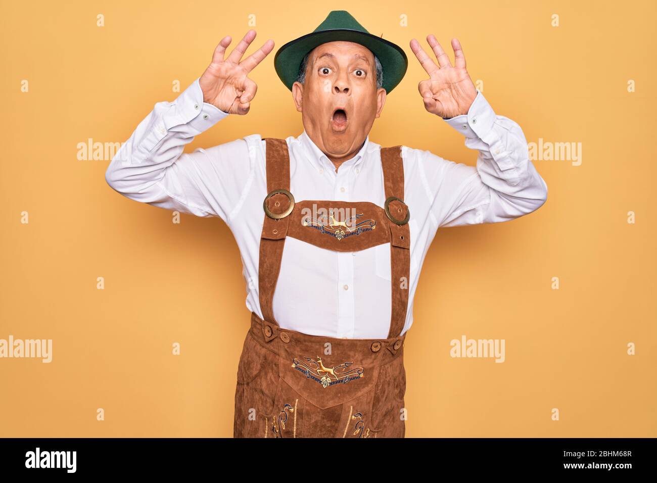 Senior grey-haired man wearing german traditional octoberfest suit over ...