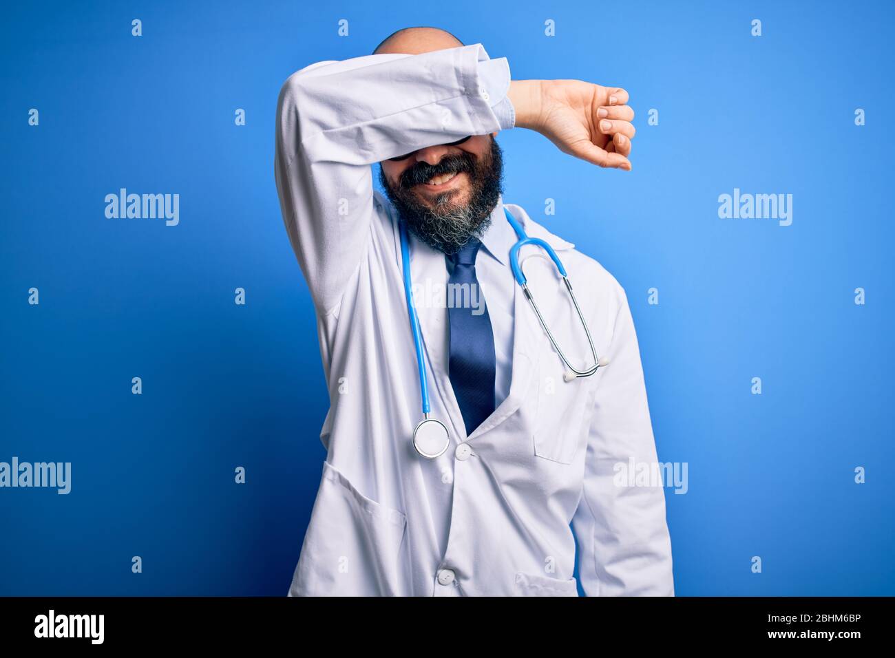 Handsome bald doctor man with beard wearing glasses and stethoscope ...