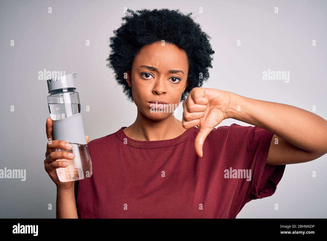 Young African American afro woman with curly hair drinking bottle of ...