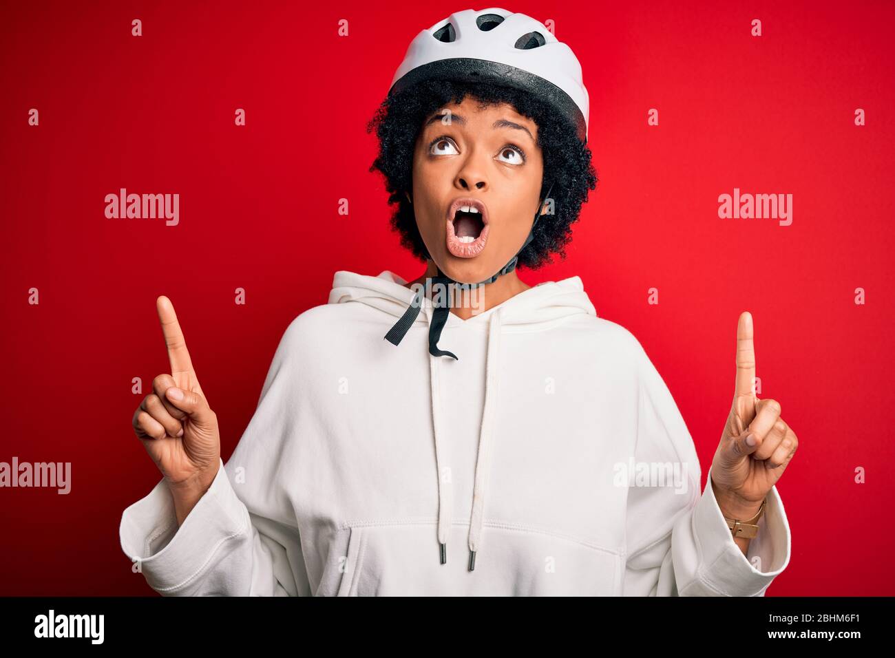 Young African American afro cyciling woman with curly hair wearing bike ...