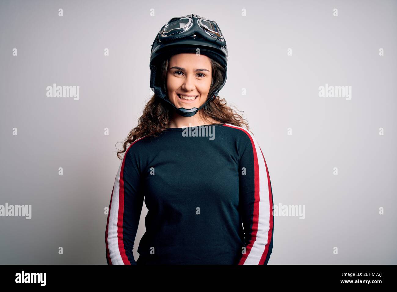 Beautiful motorcyclist woman with curly hair wearing moto helmet over ...