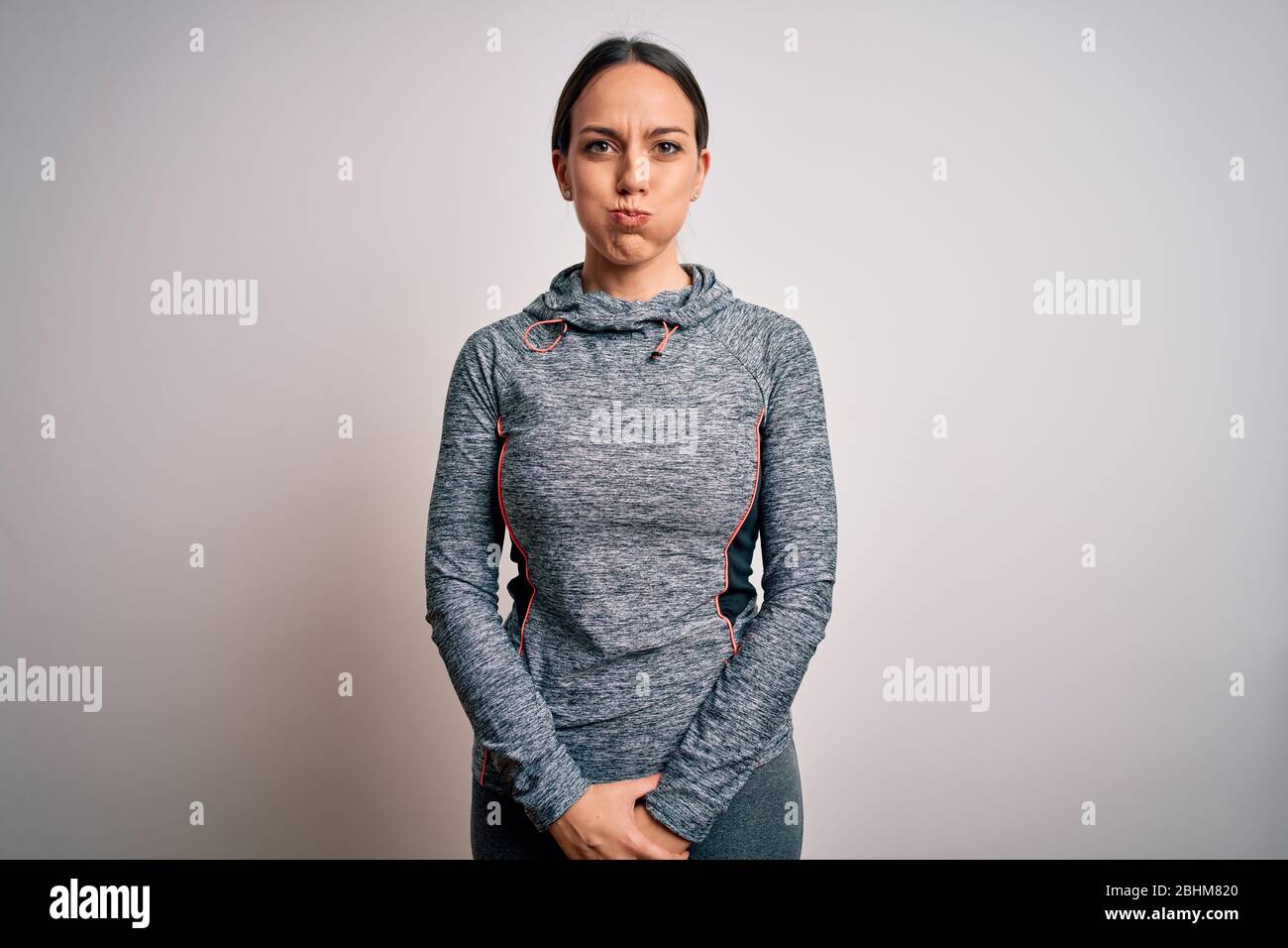 Young blonde fitness woman wearing sport workout clothes over isolated ...