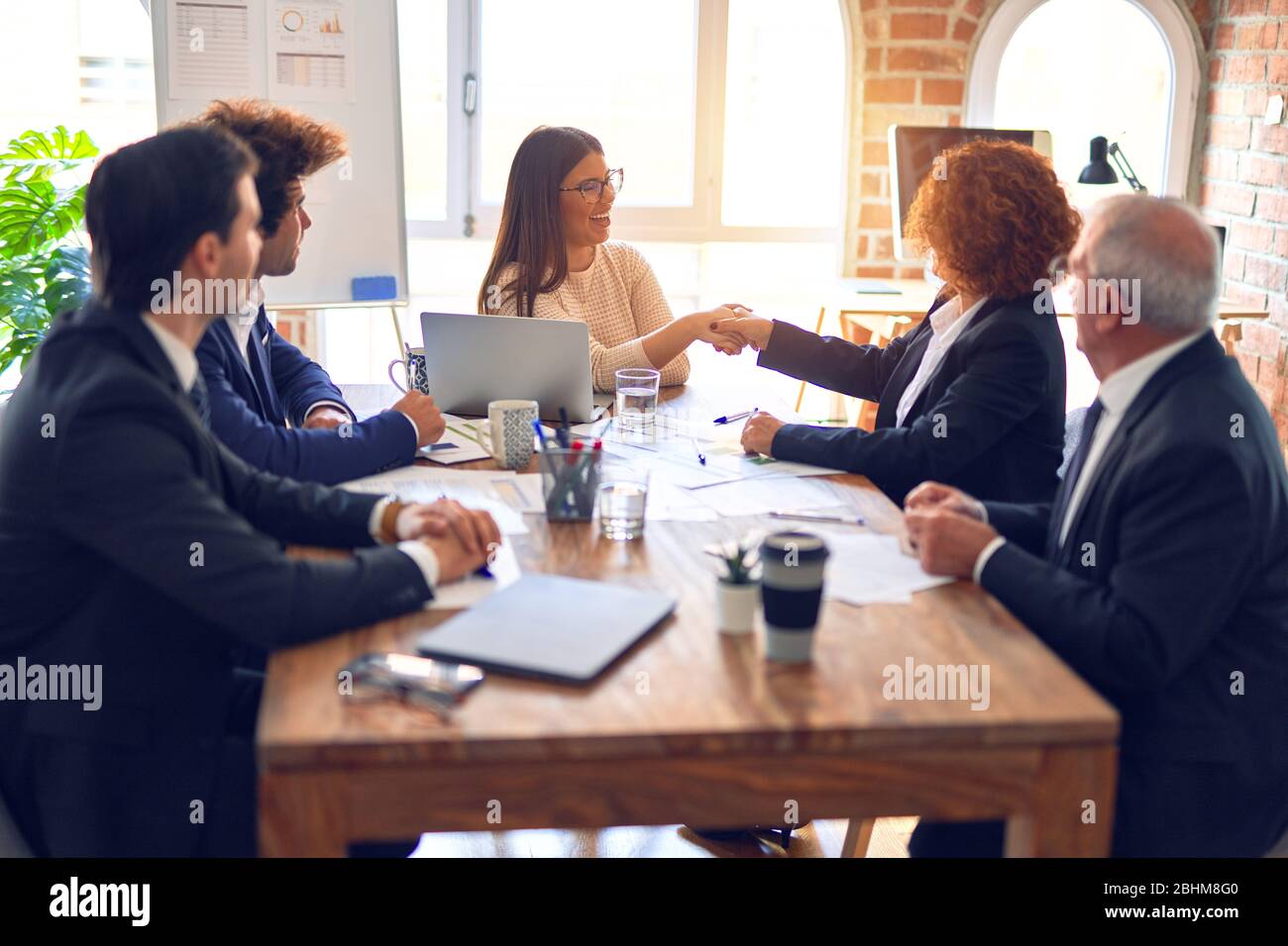 Group of business workers smiling happy and confident in a meeting ...