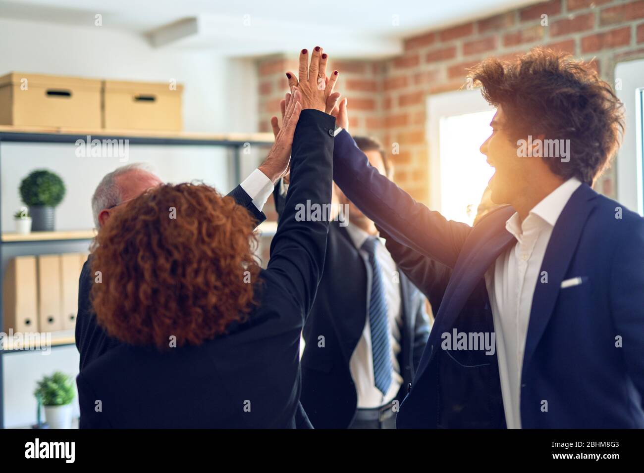 Group of business workers smiling happy and confident. Standing on a ...